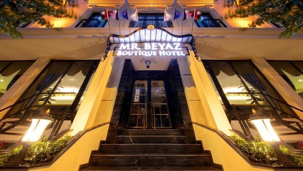 A entrada do Mr. Beyaz Boutique Hotel, com fachada imponente, janelas amplas e uma placa de destaque.