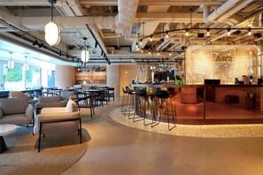 Decoração moderna com área de bar, assentos e cozinha à vista.