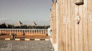 Um edifício com varanda e vista para as pirâmides.