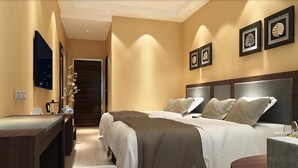 Quarto de hotel moderno com uma cama grande, mesas de cabeceira, uma escrivaninha e uma mesa redonda.