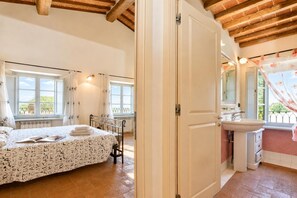 Quarto com cama, mesa de cabeceira e janela.