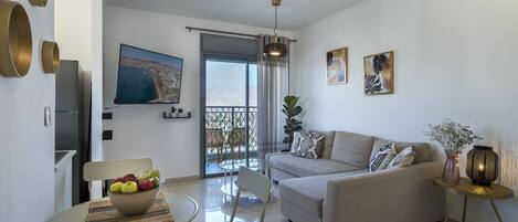 Apartamento, 1 cama Queen e sofá-cama, sacada, vista para a cidade | Área de estar | TV de tela plana 55 polegadas com canais a cabo, TV