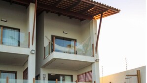 Um edifício de dois andares com piscina em frente.