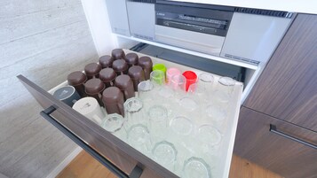 Uma gaveta com diversos copos e taças, alguns com tampas e outros sem.