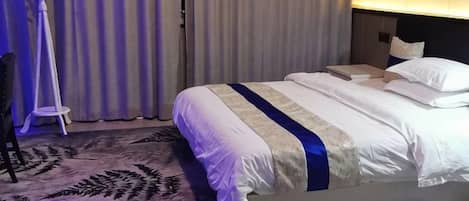 Quarto de hotel com uma cama, mesa de cabeceira e abajur.