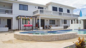 Um hotel com piscina, deck de ladrilho de pedra e uma decoração de flamingos cor-de-rosa.