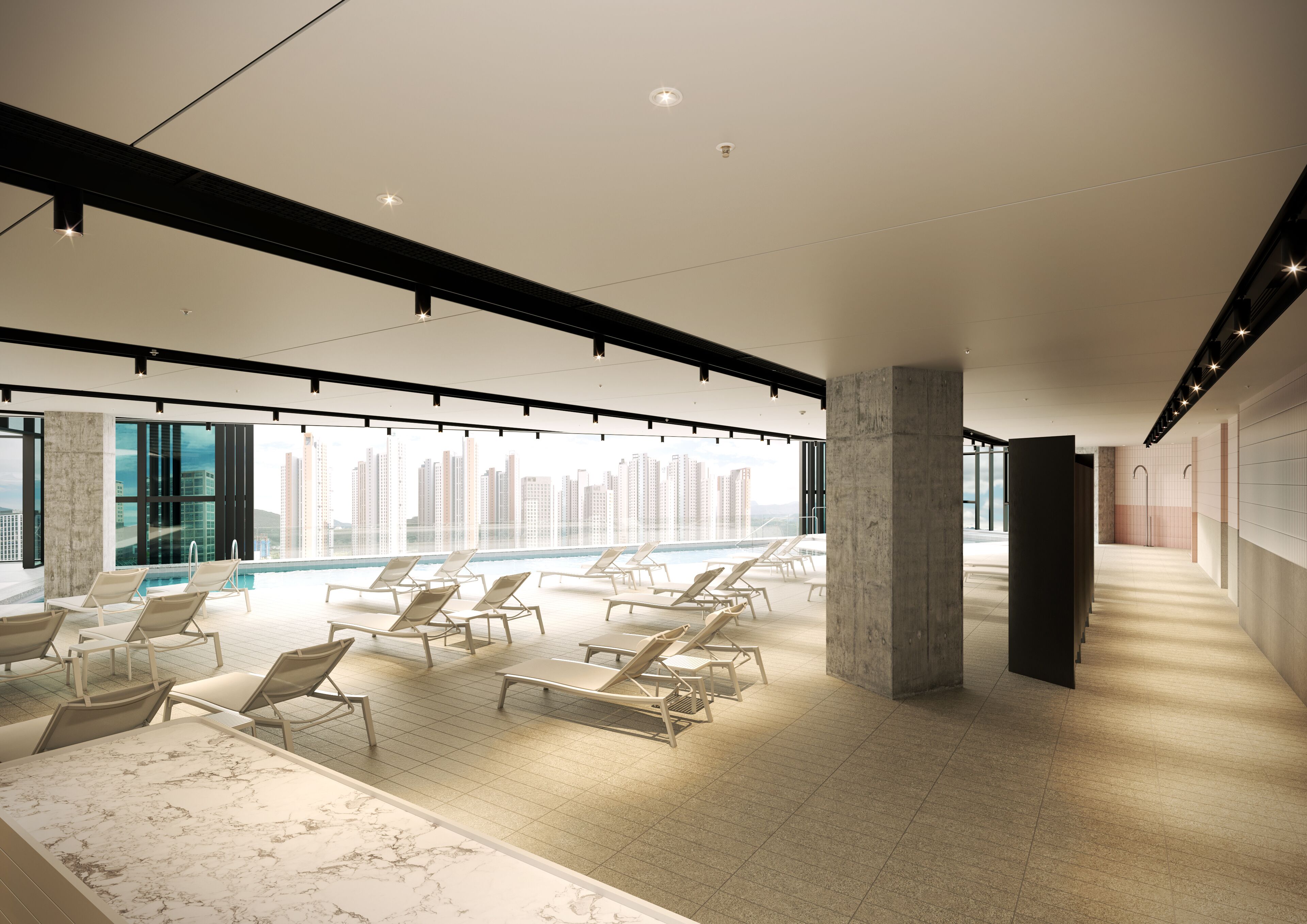 Uma área de piscina interna moderna com espreguiçadeiras e vista para edifícios altos.