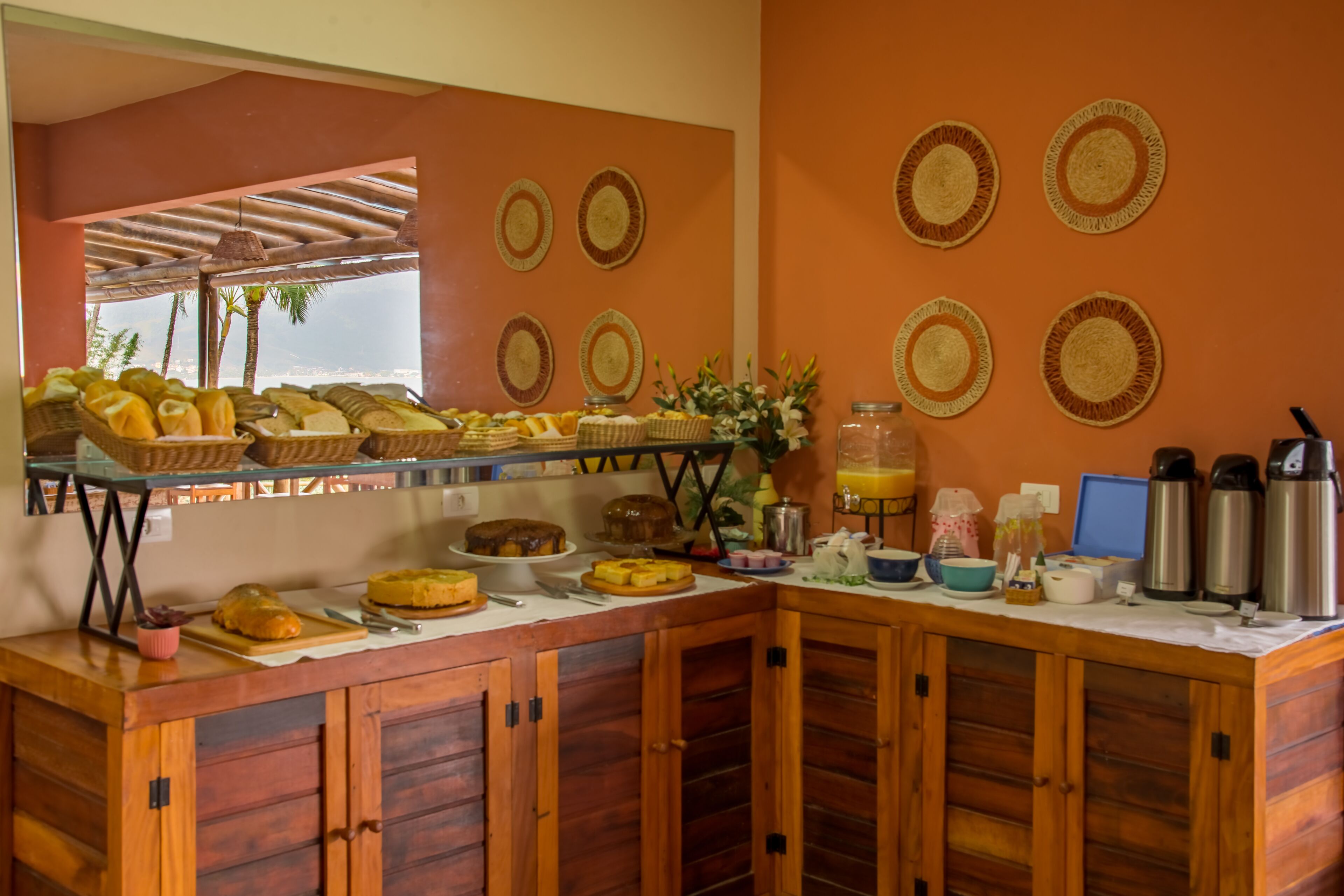 Um buffet de café da manhã com diversos produtos de panificação e uma estação de café.