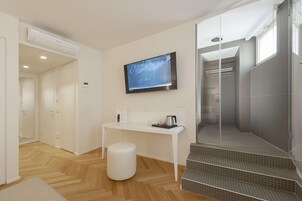 Uma casa de banho moderna com chuveiro, sanita e lavatório.