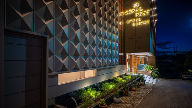 Entrada de um hotel com fachada geométrica e uma placa indicando 