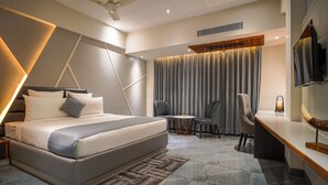 Quarto de hotel moderno com uma cama grande, uma escrivaninha e uma cadeira.