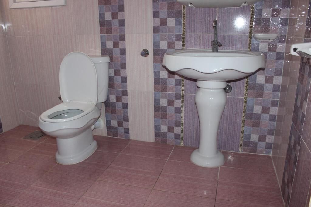 Casa de banho com sanita e lavatório assentado.