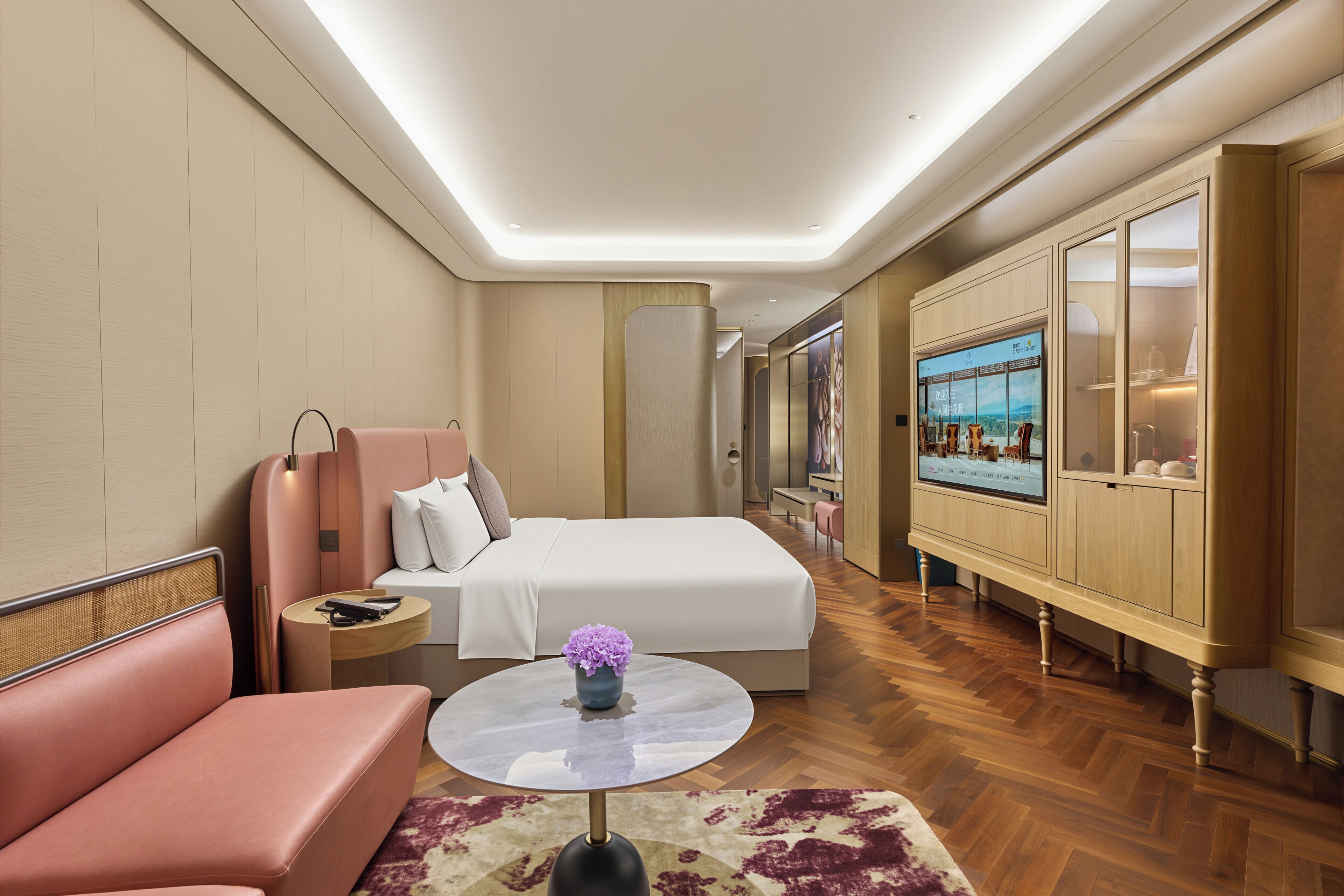 Quarto de hotel com cama, sofá, escrivaninha com luminária, televisão e guarda-roupa.