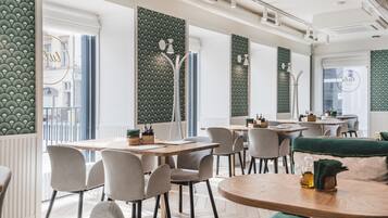 Uma sala de jantar moderna com pé direito alto, janelas amplas e paredes com padrão verde.