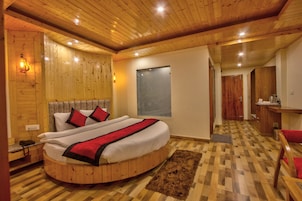 Uma cama redonda de madeira com cabeceira, mesa de cabeceira e criado-mudo.