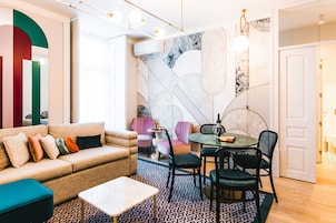 Uma sala de estar moderna com sofá, mesa de centro e área de jantar com cadeiras e mesa.