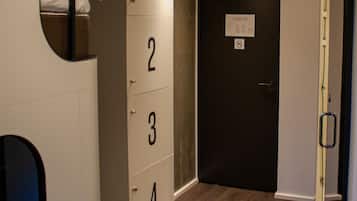 Corredor com armários individuais numerados e uma porta com placa de proibido fumar.