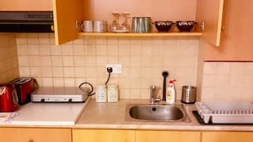 Apartamento standard, 1 quarto | Cozinha privada | Geladeira, cooktop, torradeira, talheres/pratos/utensílios de cozinha