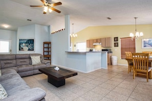 Sala de estar com sofá, mesa de centro e ventilador de teto.