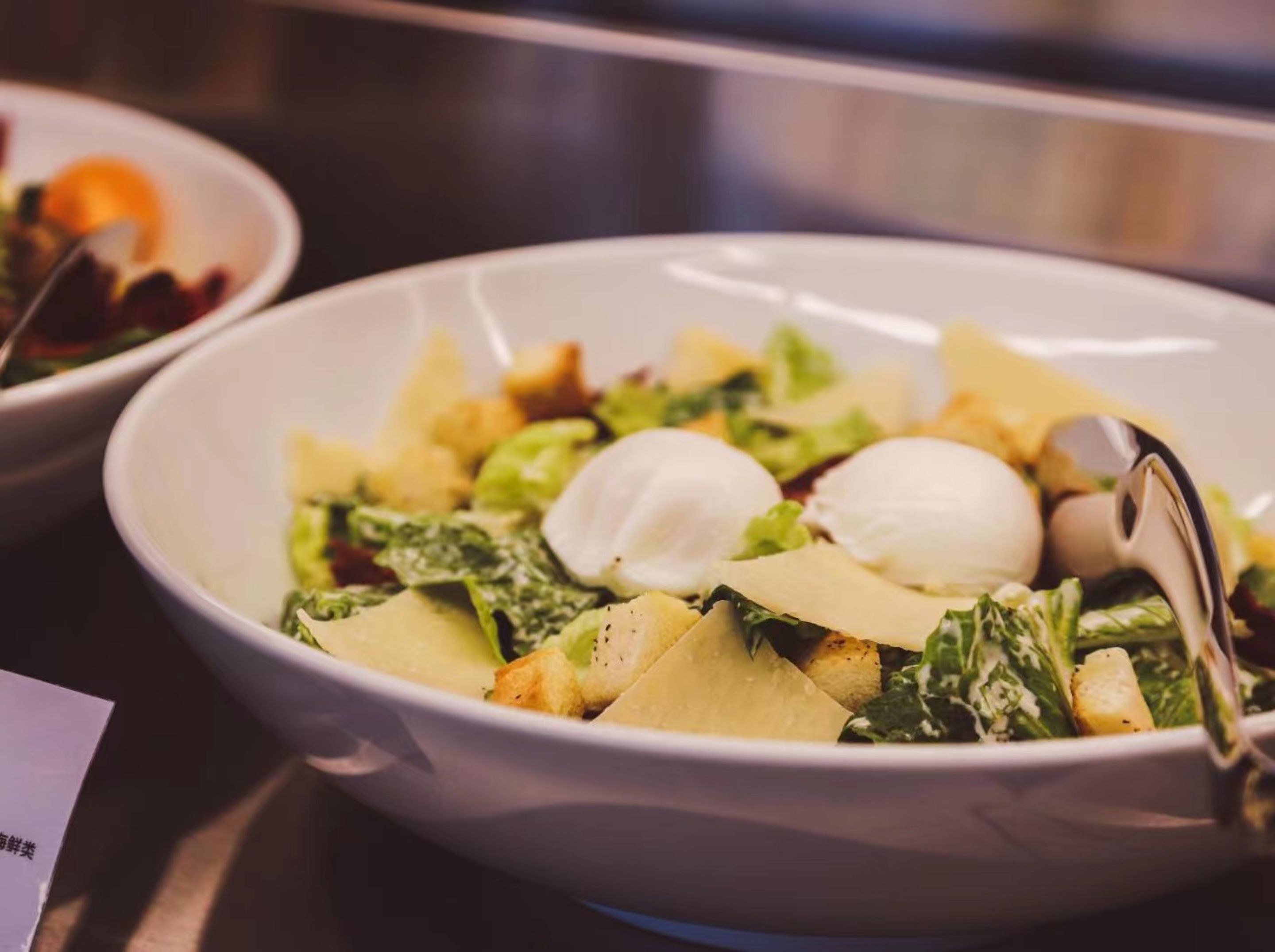 Uma salada com folhas verdes, queijo e ovo cozido.