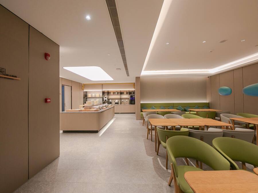 Uma área de refeições moderna com um balcão central, assentos e vista para a cozinha.