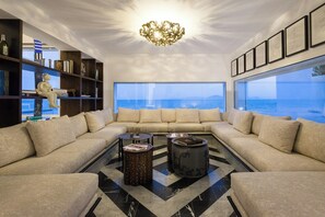 Uma sala de estar moderna com um sofá grande, uma mesa de centro e uma estante.
