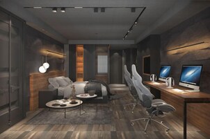 Um espaço de escritório moderno com sofá, escrivaninha e vários monitores.