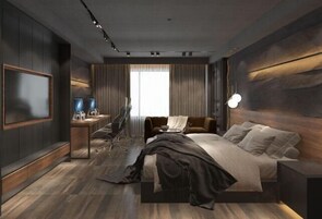 Quarto moderno com cama, escrivaninha, cadeira e televisão.