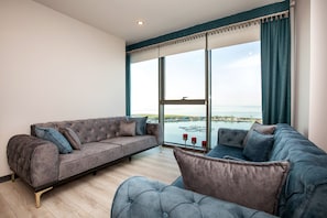 Suíte standard, 2 quartos, vista para o mar | Área de estar | TV LED 82 cm com canais via satélite, TV