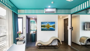 Um hall de hotel moderno com detalhes em verde-água, um ar condicionado fixado na parede, um grande quadro com paisagem e uma poltrona de design exclusivo.
