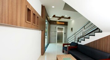 Um interior moderno com escada, sofá e área de recepção.