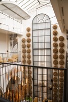 Um interior moderno com teto de vidro, escadaria e parede decorada com objetos esféricos.