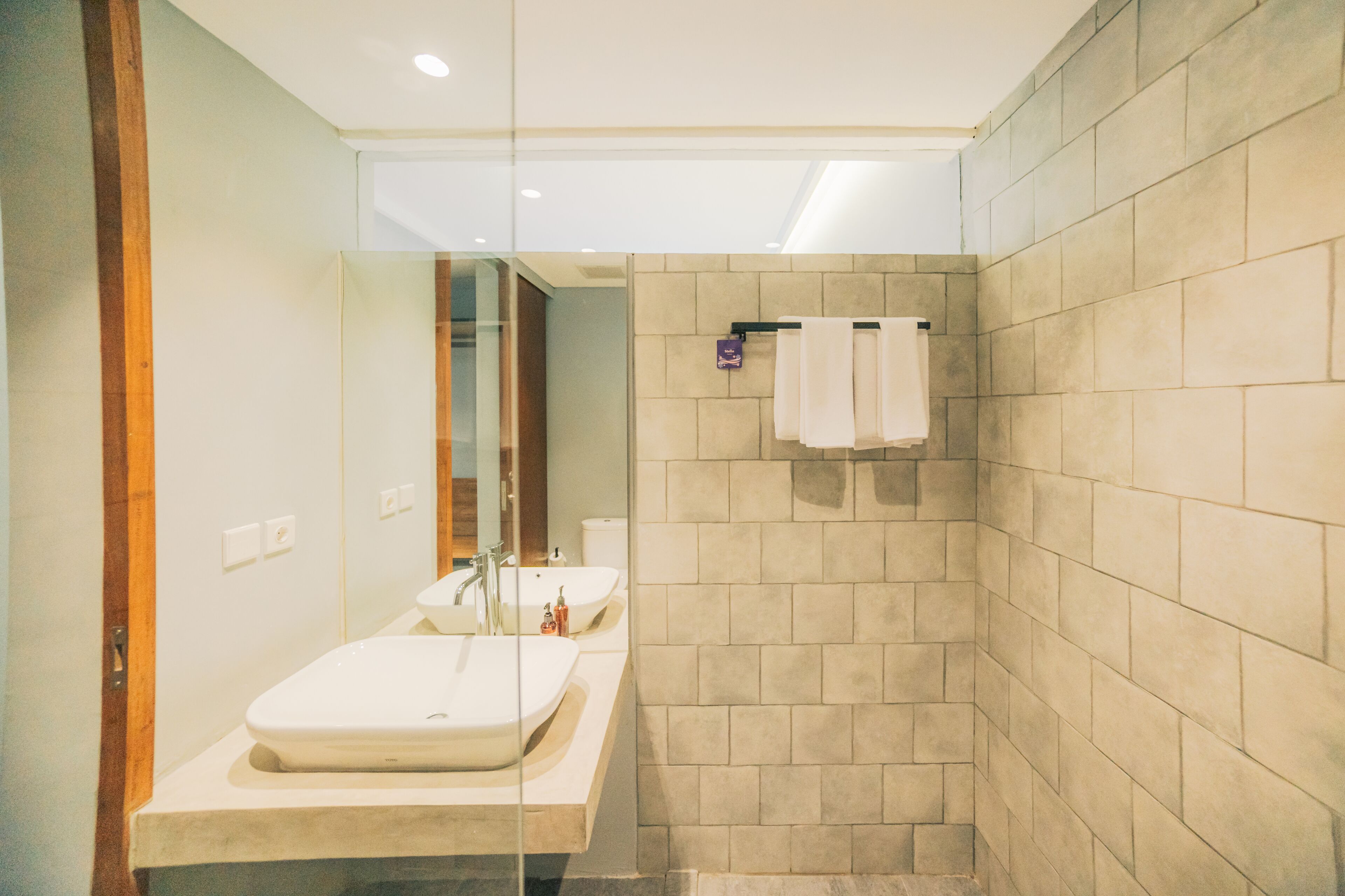 Uma casa de banho moderna com um espelho grande, duas bacias e uma área de chuveiro.