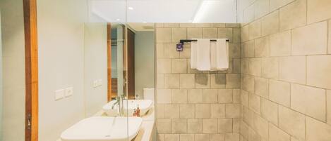 Uma casa de banho moderna com um espelho grande, duas bacias e uma área de chuveiro.