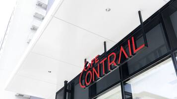 Um edifício com uma placa grande exibindo a inscrição 'Café Central' em letras vermelhas.