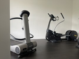 Academia com máquinas de cardio, incluindo uma elíptica e uma bicicleta ergométrica.