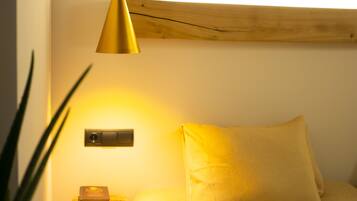 Quarto com cabeceira de madeira, mesa de cabeceira com abajur e cama com travesseiro.