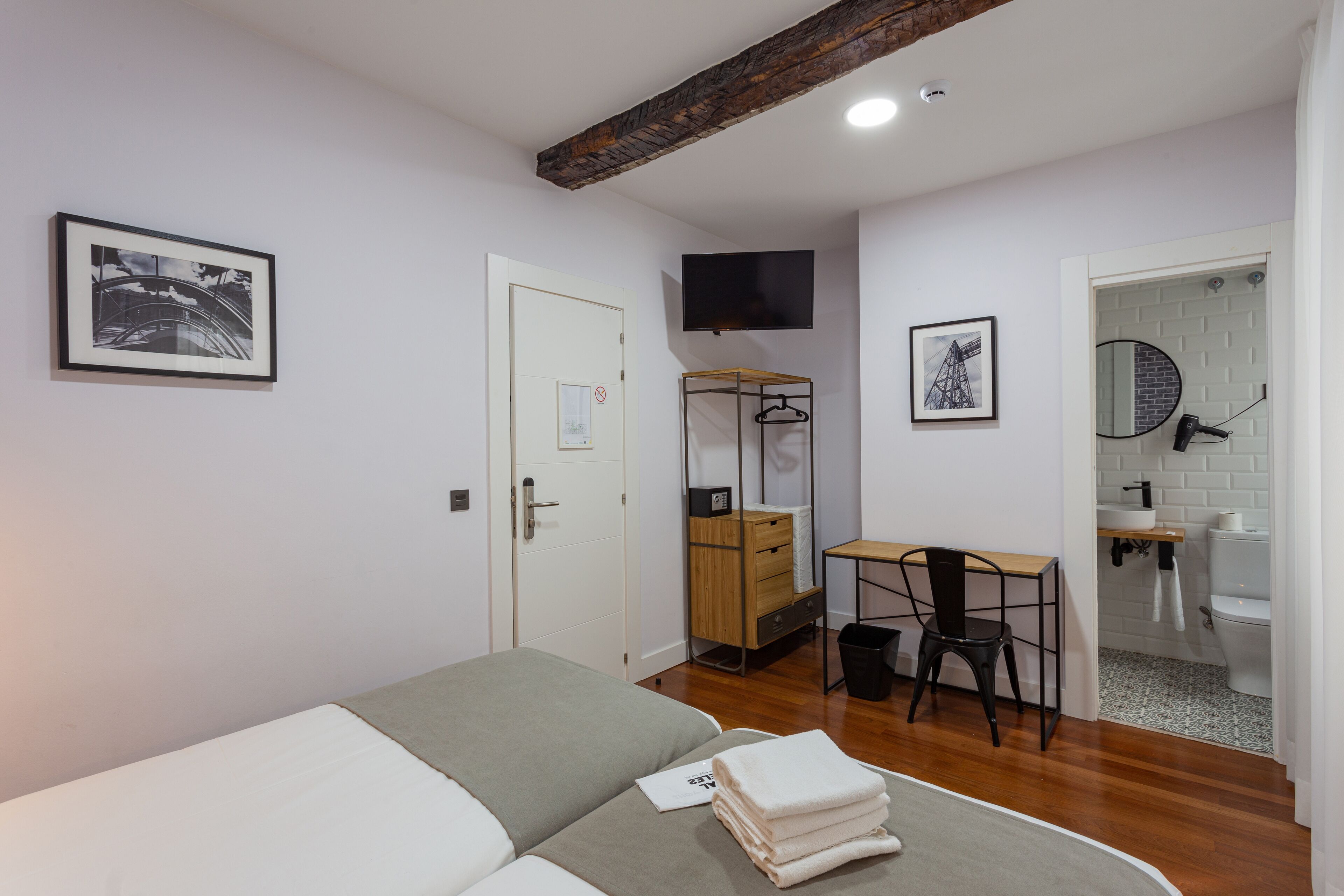 Quarto com cama, escrivaninha e cadeira. Inclui banheiro com vaso sanitário e pia.