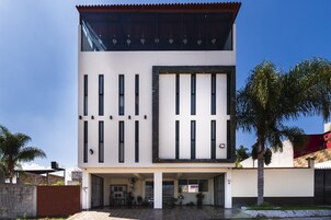 Um edifício moderno de dois andares com teto plano, janelas amplas e área de entrada coberta.