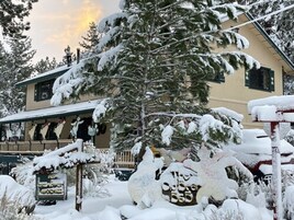 Um edifício coberto de neve com varanda e uma placa.