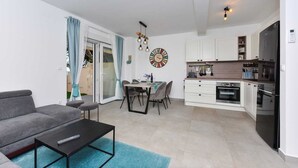 Um apartamento moderno com sala de estar, espaço para refeições e cozinha.