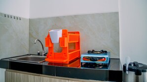 Cozinha equipada com pia, fogão a gás e cafeteira.