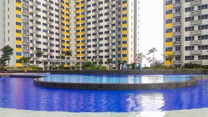 Edifício residencial com várias varandas e área de piscina.