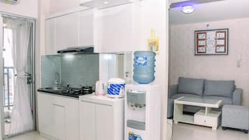 Um frigorífico, uma placa de cozinha, utensílios de cozinha