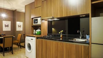 Um frigorífico, uma placa de cozinha, utensílios de cozinha