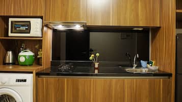 Um frigorífico, uma placa de cozinha, utensílios de cozinha