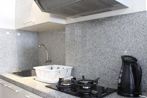 Um frigorífico, uma placa de cozinha, utensílios de cozinha 