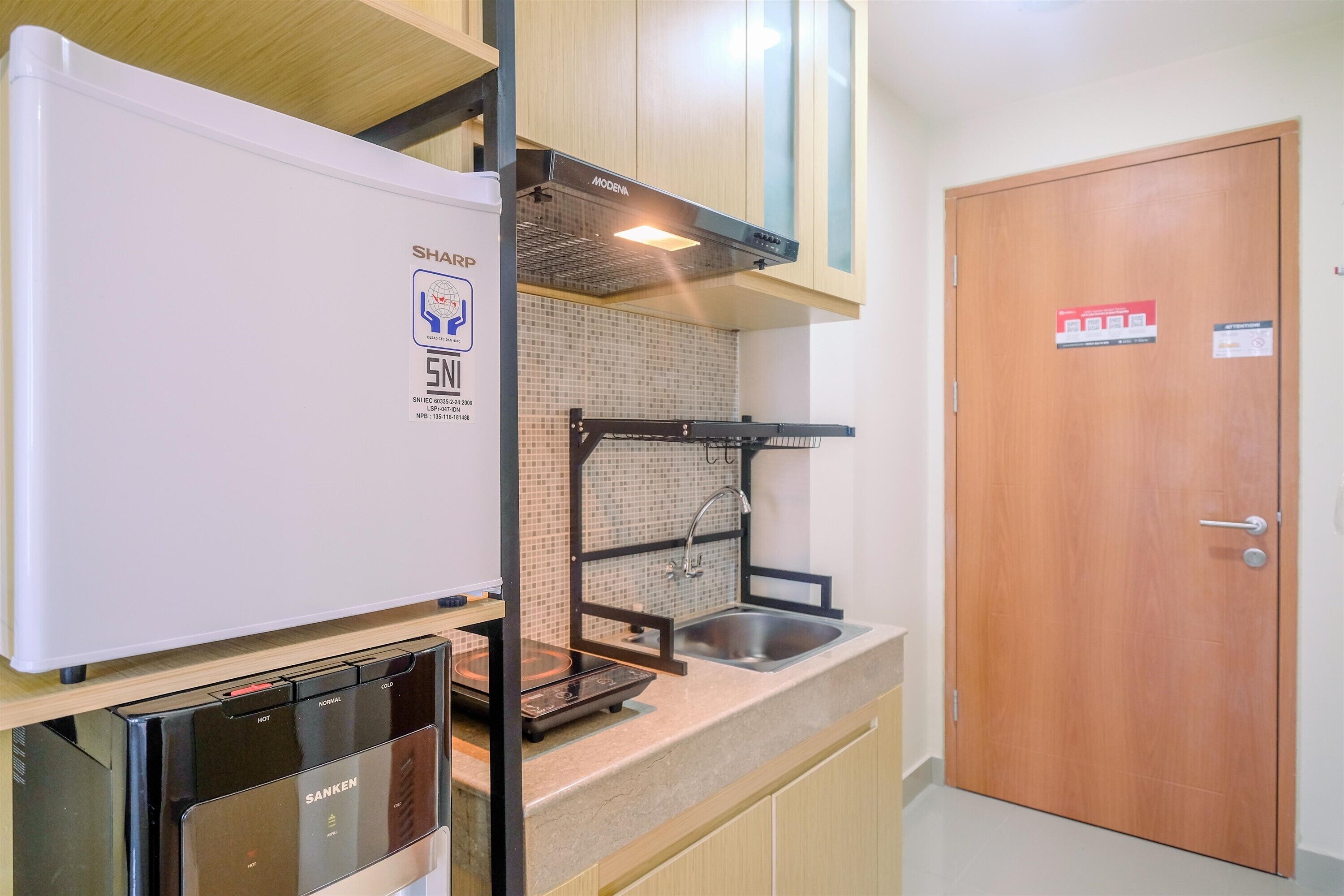 Uma cozinha compacta com geladeira branca, forno embutido, pia e armários de madeira.