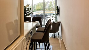Uma cozinha moderna com área de refeições, janelas amplas e vista para o exterior.