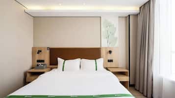 Quarto de hotel com uma cama grande, duas mesas de cabeceira, uma cabeceira e uma janela com cortinas.